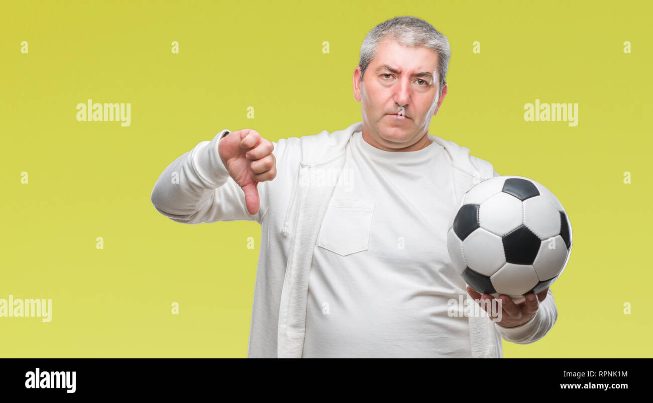 Handsome senior man holding soccer football ball over isolated ...