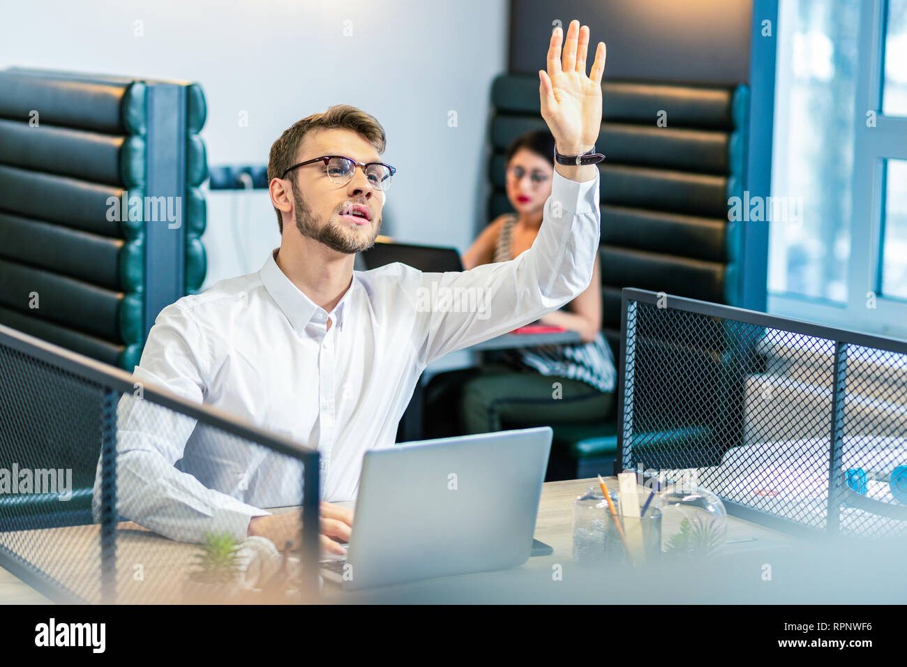 Delighted young male person raising his arm Stock Photo - Alamy