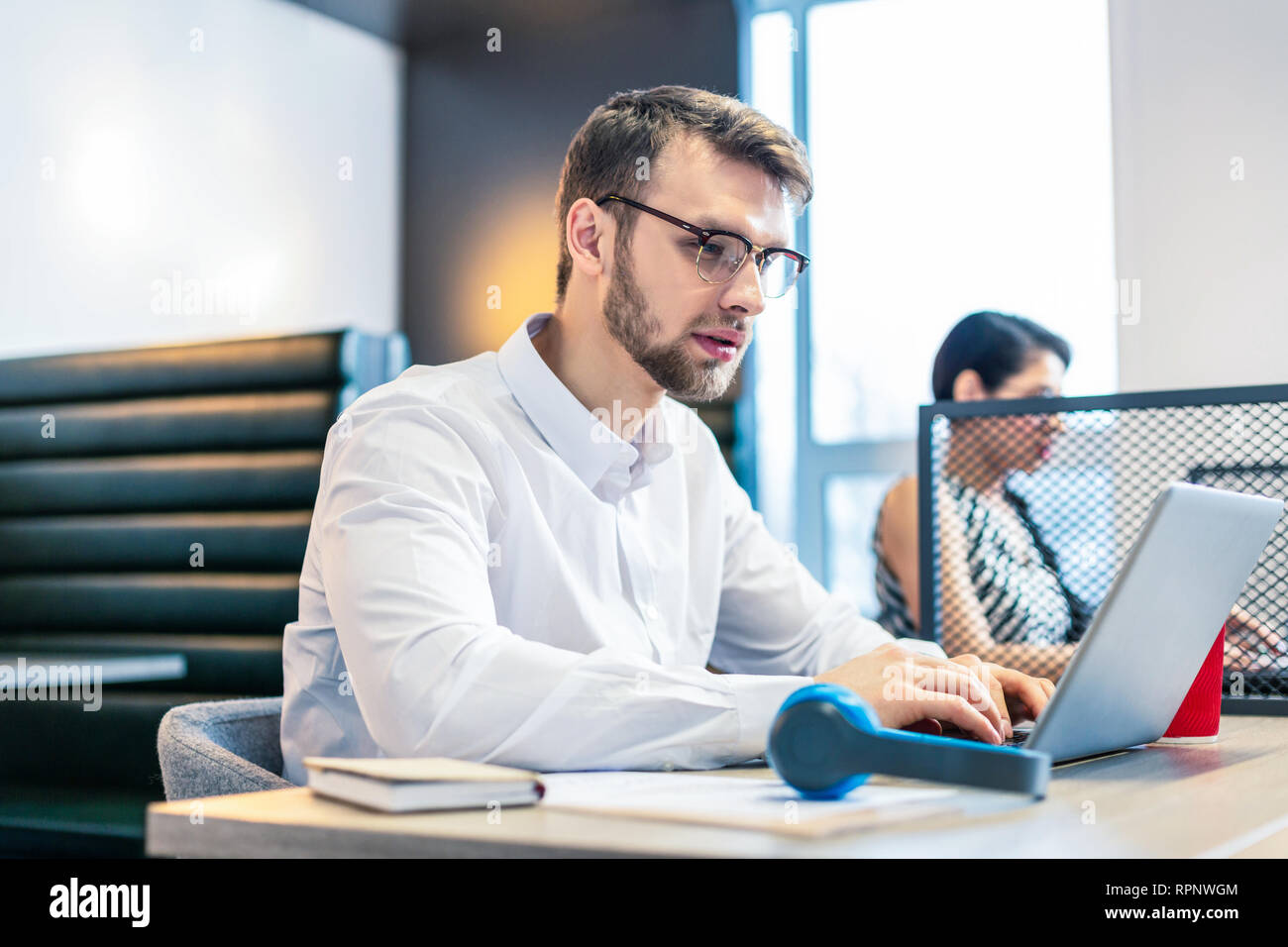 Serious young office worker staring at screen of computer Stock Photo - Alamy