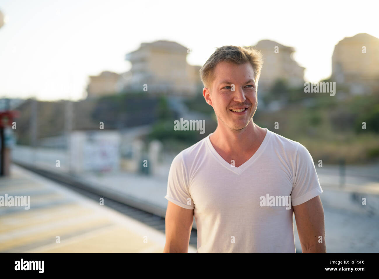 Young Happy Tourist Man Thinking While Waiting At The Train Station ...
