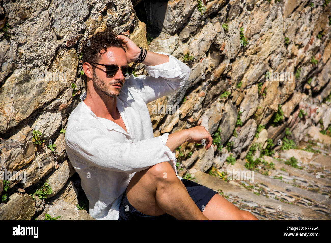 Relaxing stylish man sitting on stone stairs Stock Photo - Alamy