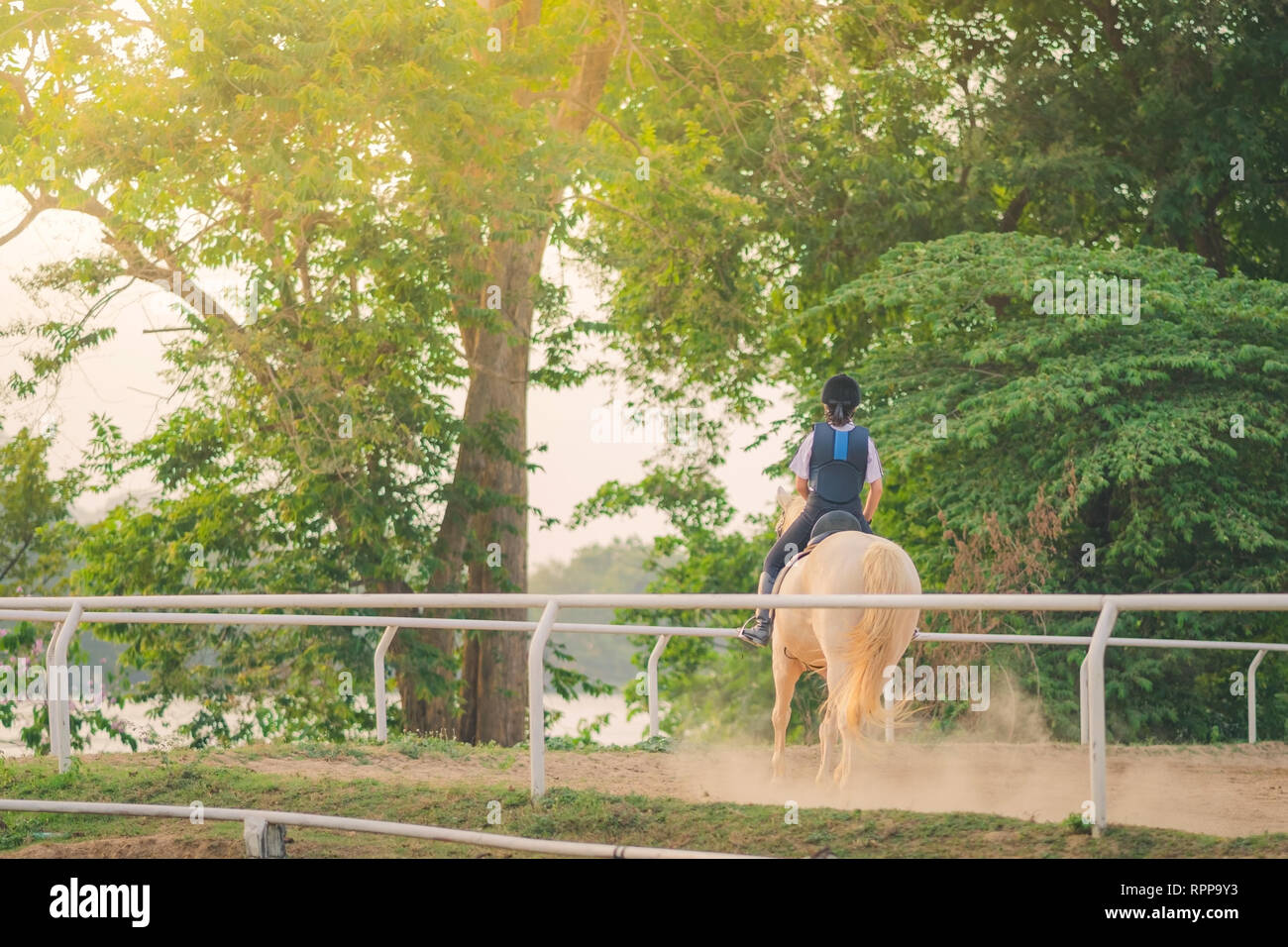 Kids learn to ride a horse near the river before sunset Stock Photo - Alamy