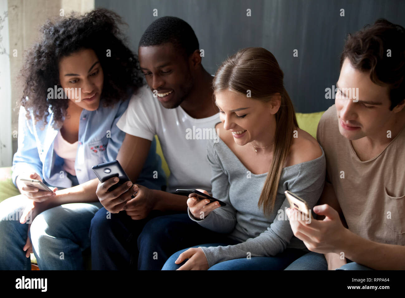 Happy multiracial people sitting in row, using phones together Stock ...