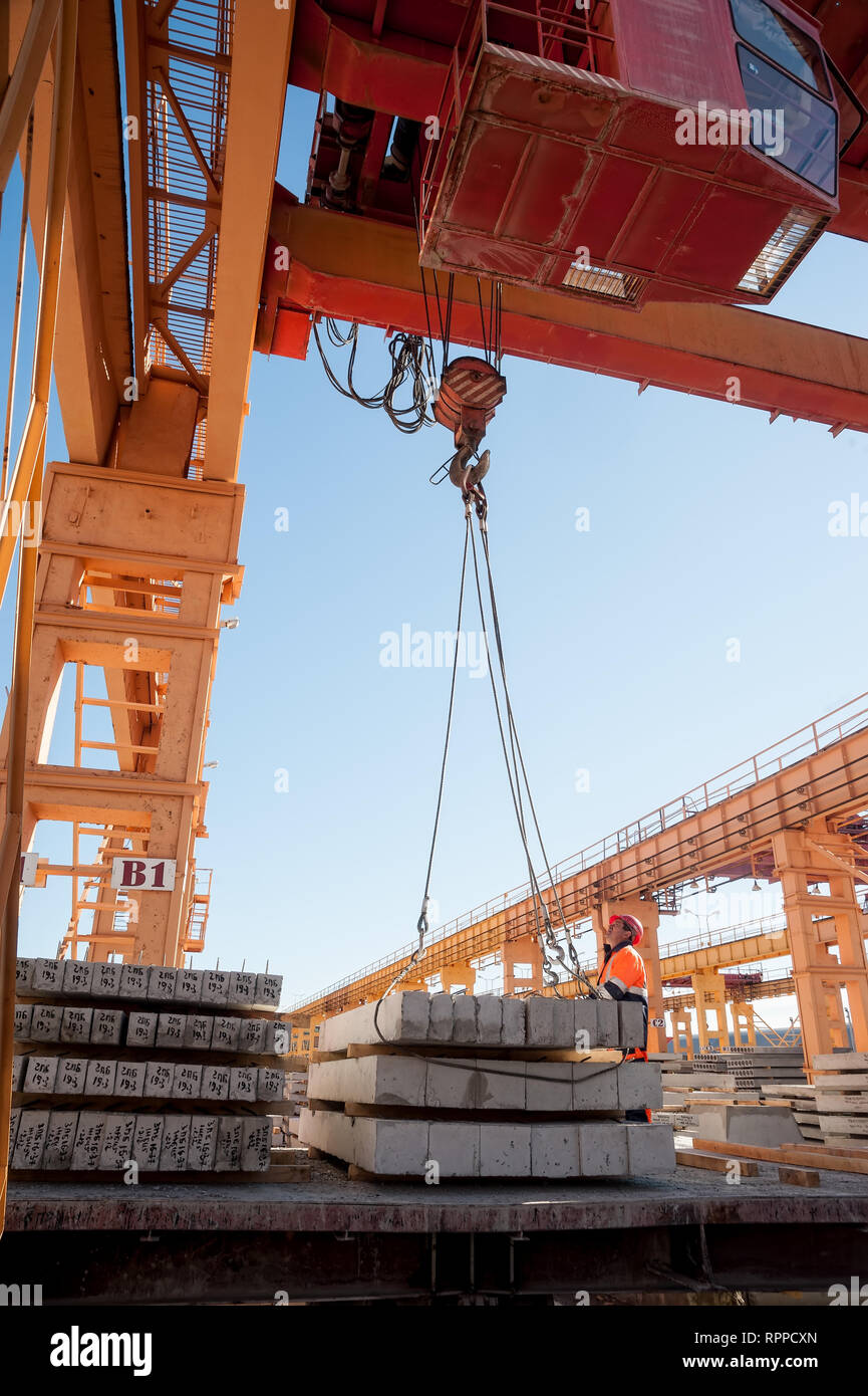 Slinger accepts plates from crane operator Stock Photo - Alamy
