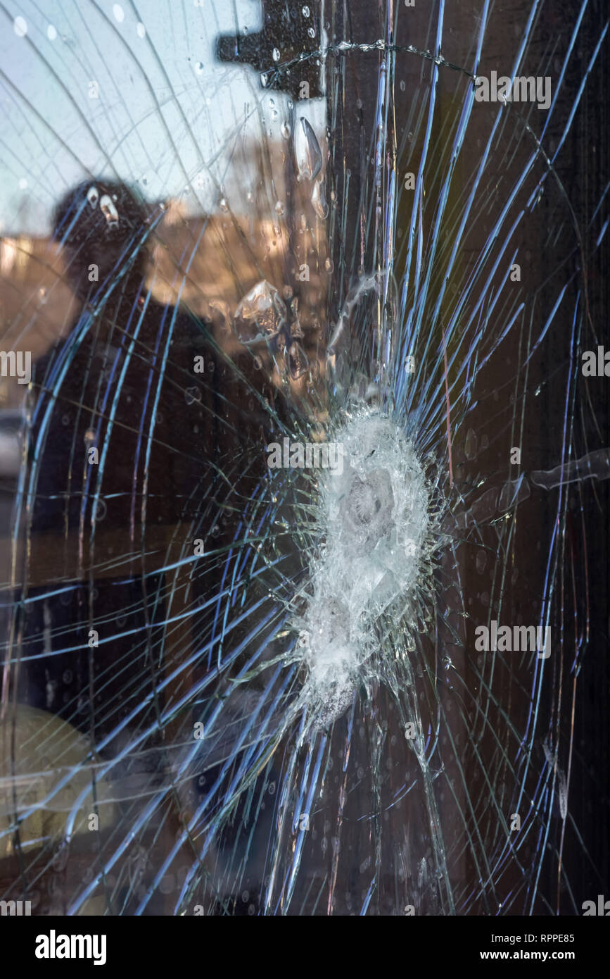 A broken window with a reflection of a person Stock Photo - Alamy