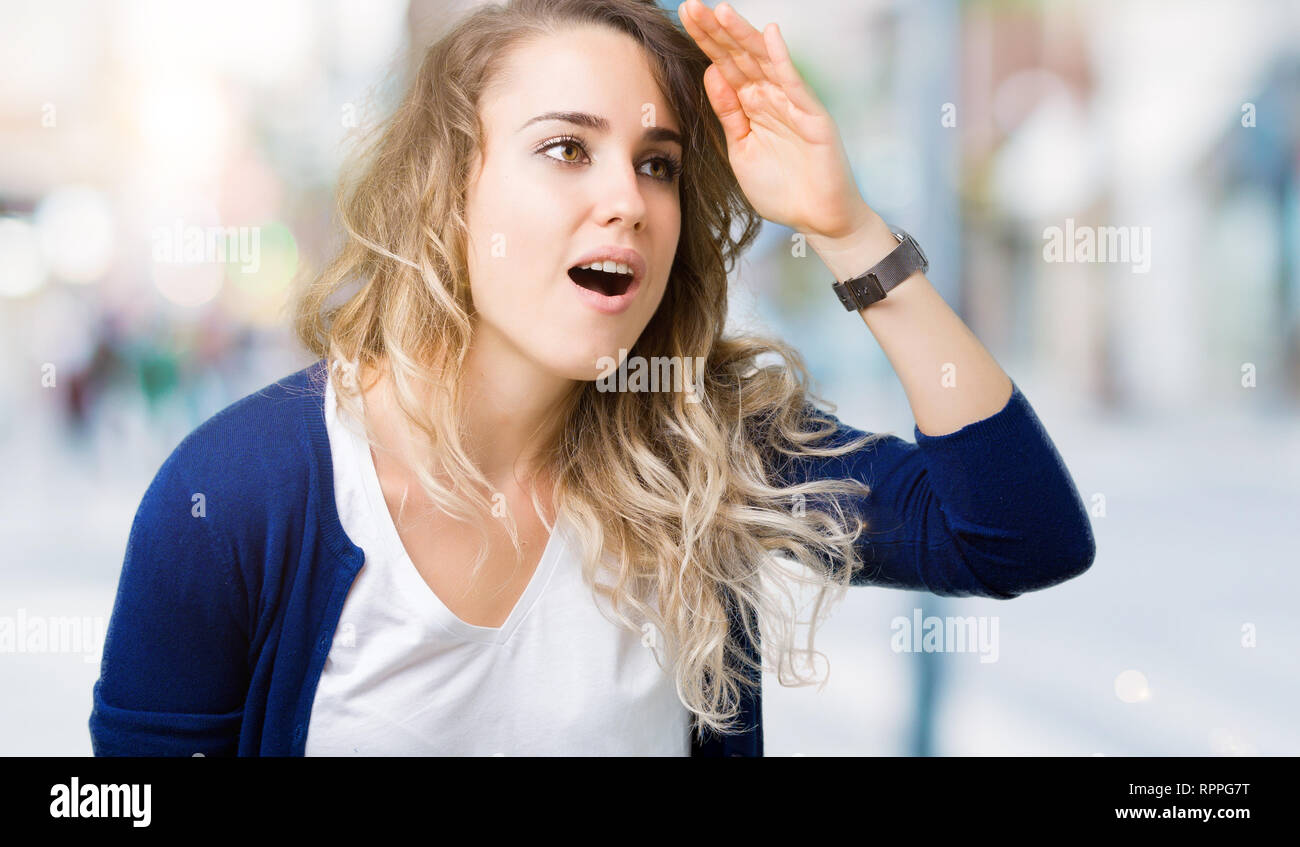 Beautiful young blonde woman over isolated background very happy and ...