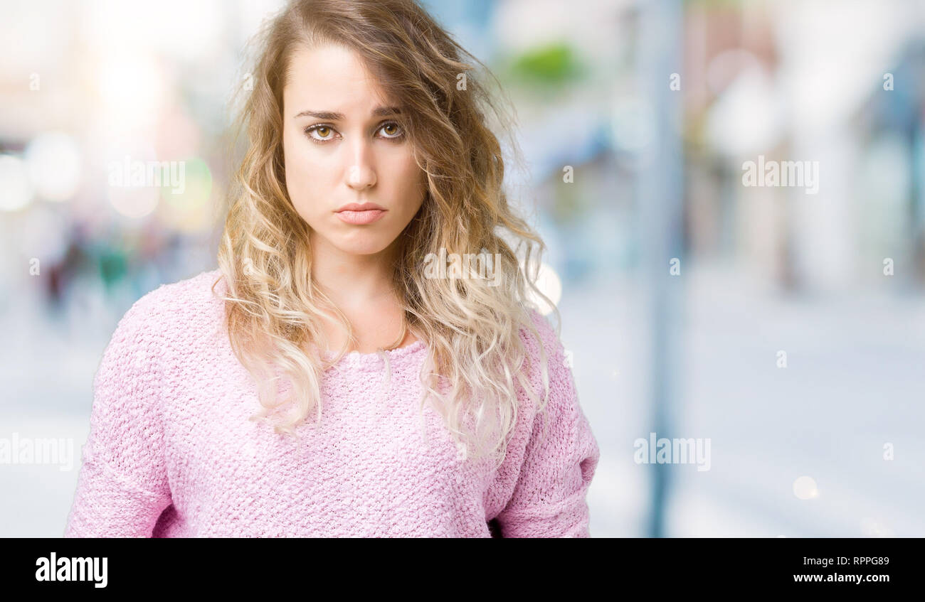 Beautiful young blonde woman over isolated background depressed and ...