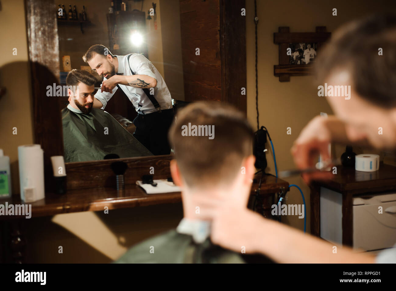 Master cuts hair and beard of men in the barbershop Stock Photo - Alamy