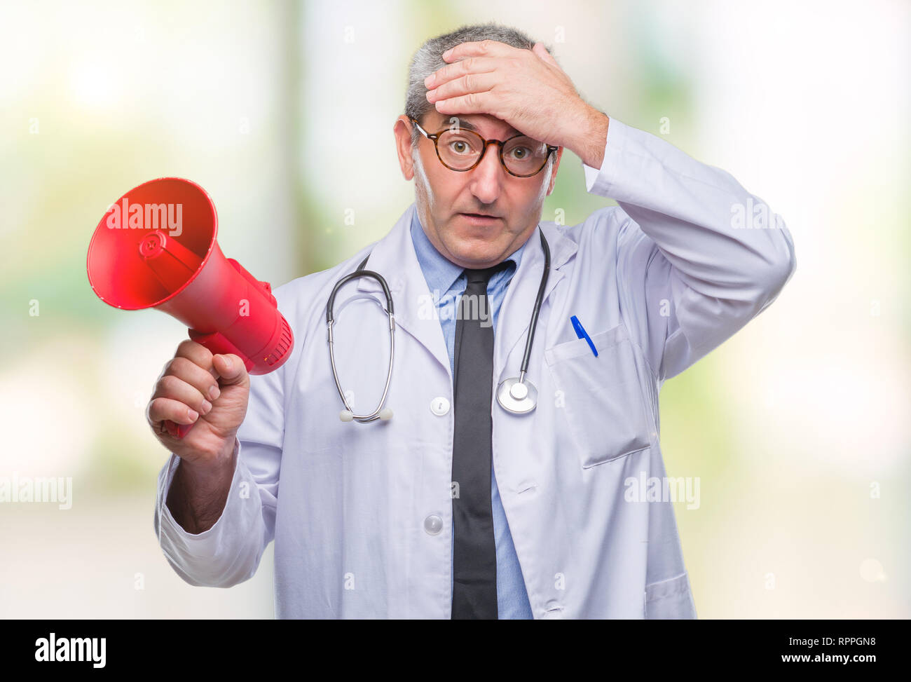 Handsome senior doctor man yelling through megaphone over isolated ...