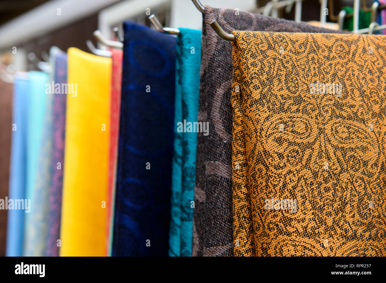 Rows of fabrics hanging at a market stall Stock Photo - Alamy
