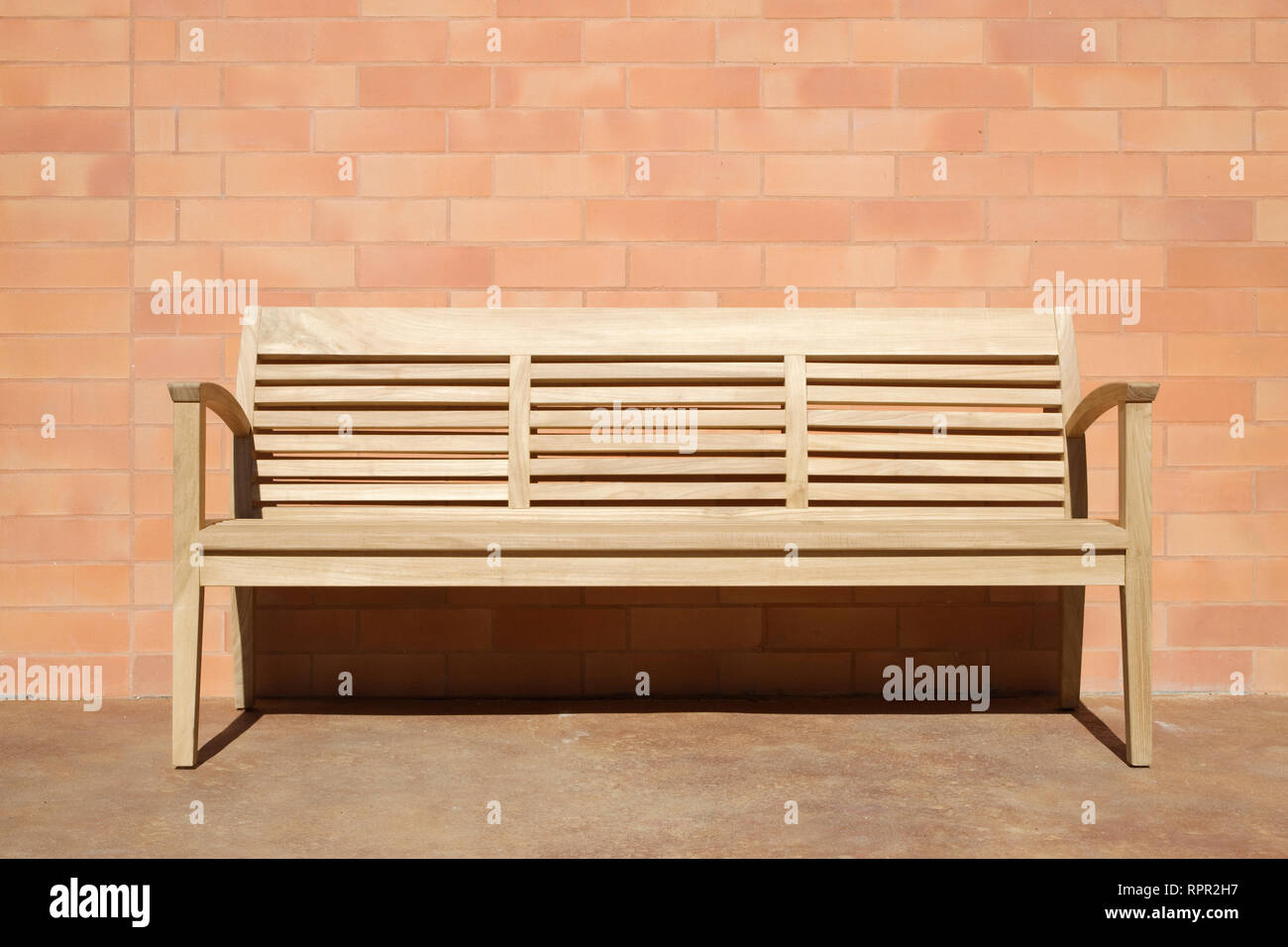 Wooden Bench Set Against Brick Wall Stock Photo - Alamy