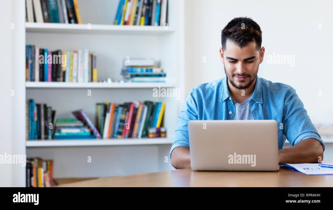 Mexican hipster man working with computer indoor at desk at home Stock ...