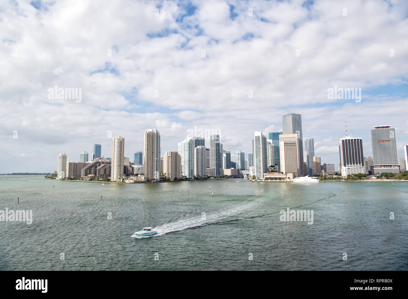 Aerial view of Miami skyscrapers with blue cloudy sky,white boat ...