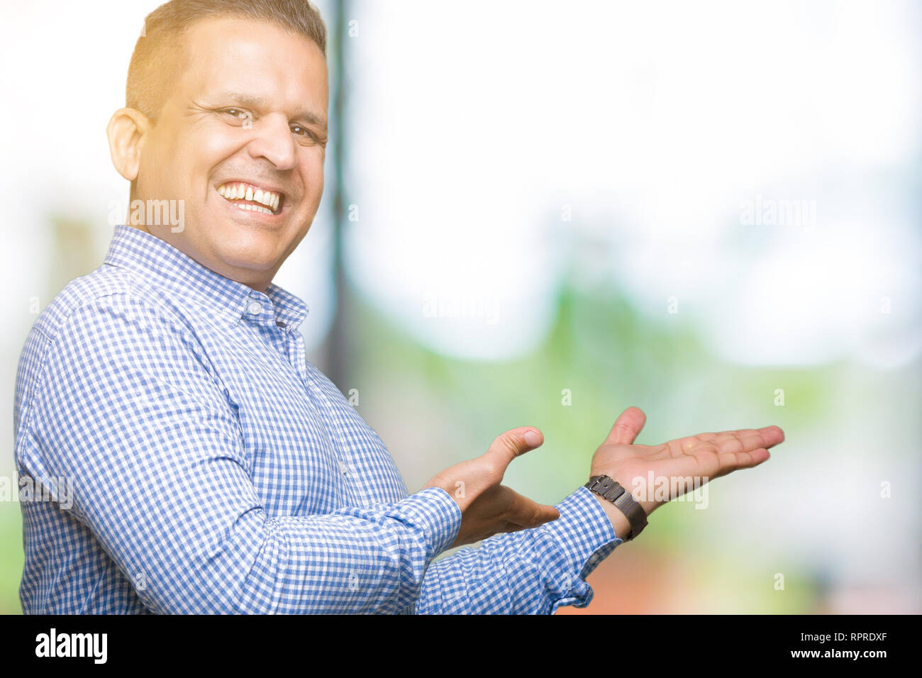 Middle age arab business man over isolated background Inviting to enter ...