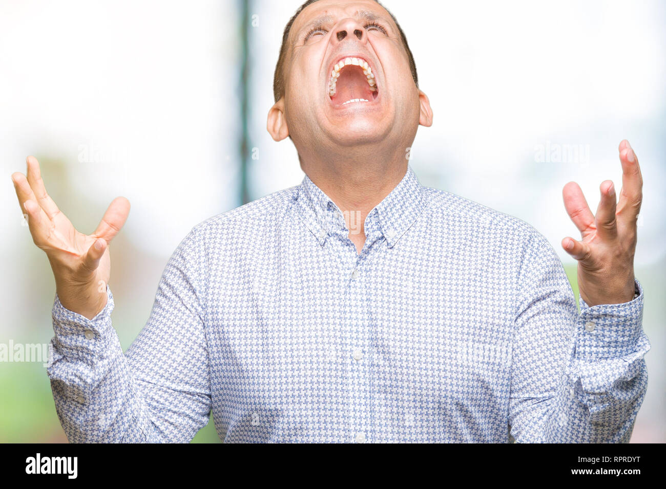 Middle age arab business man over isolated background crazy and mad ...