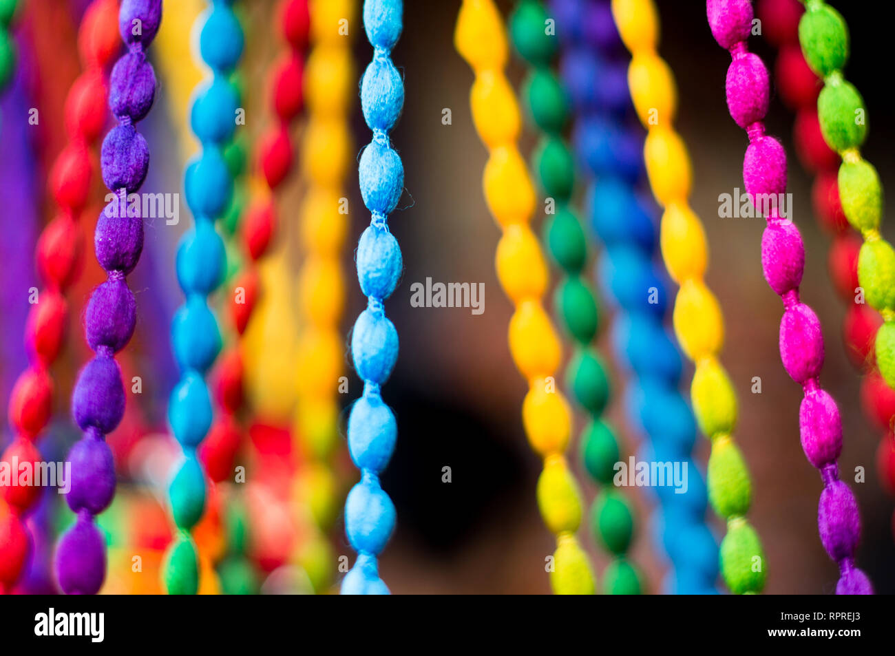 Multicolored braided strings hanging tight with a blurred background ...