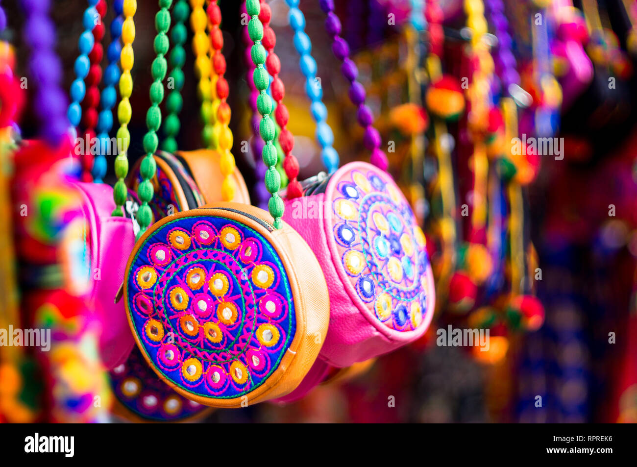Colorful, textile, hand made hand bags hanging in a shop in Gujarat ...