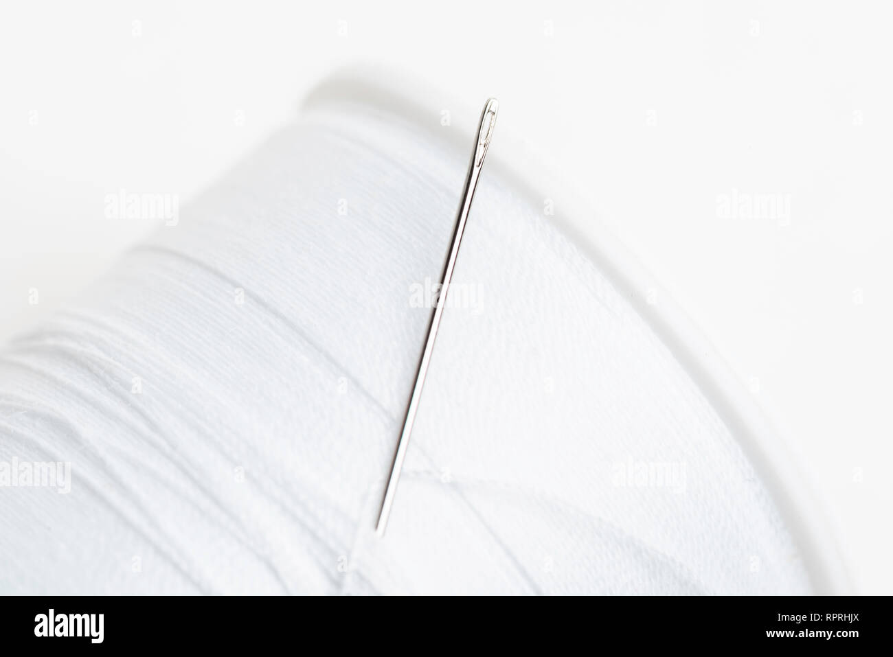 An extreme close-up or a macro shot of a spool of white thread with an ...