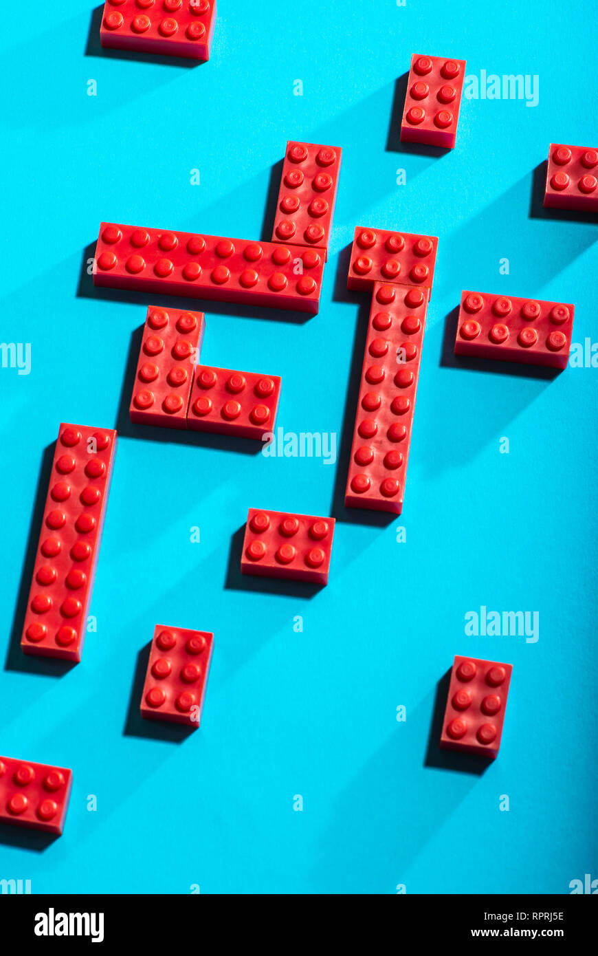 Red plastic geometric cubes contrasted on blue background. Construction ...