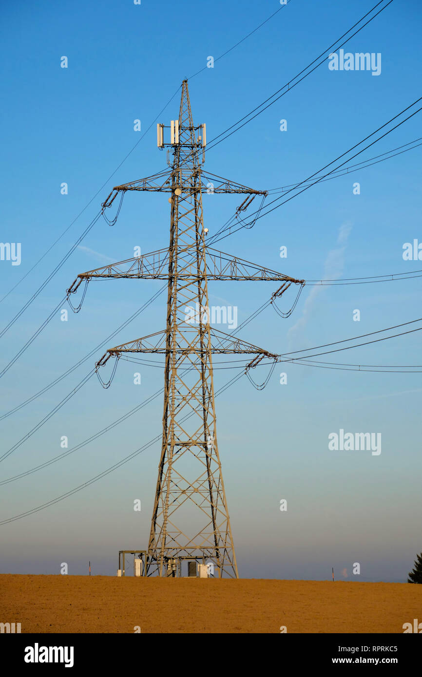 A High Voltage Power Pylon With GSM or 4G Antennas Against a Bright ...