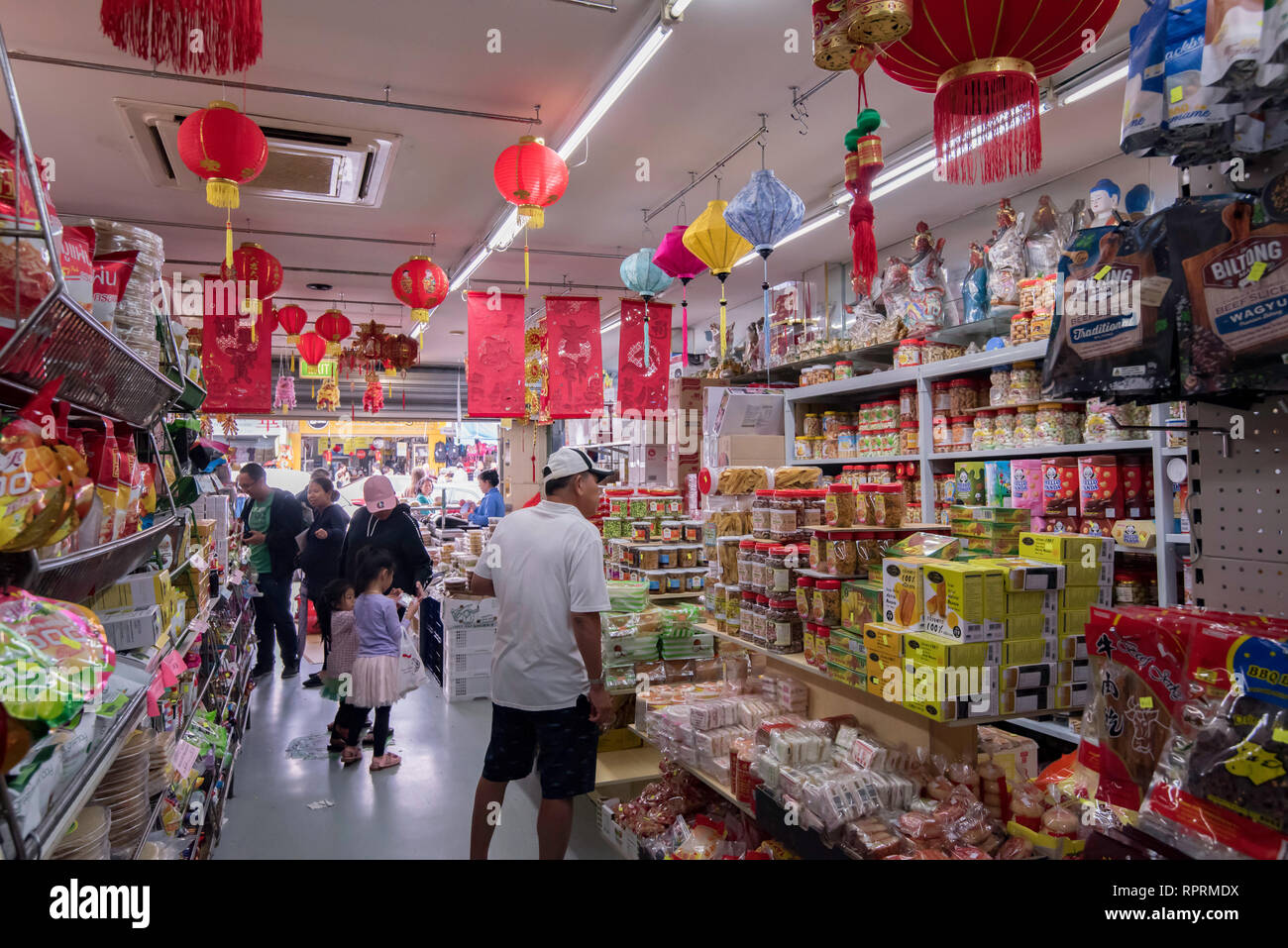 Colourful lanterns hanging and people shopping in an Asian supermarket ...