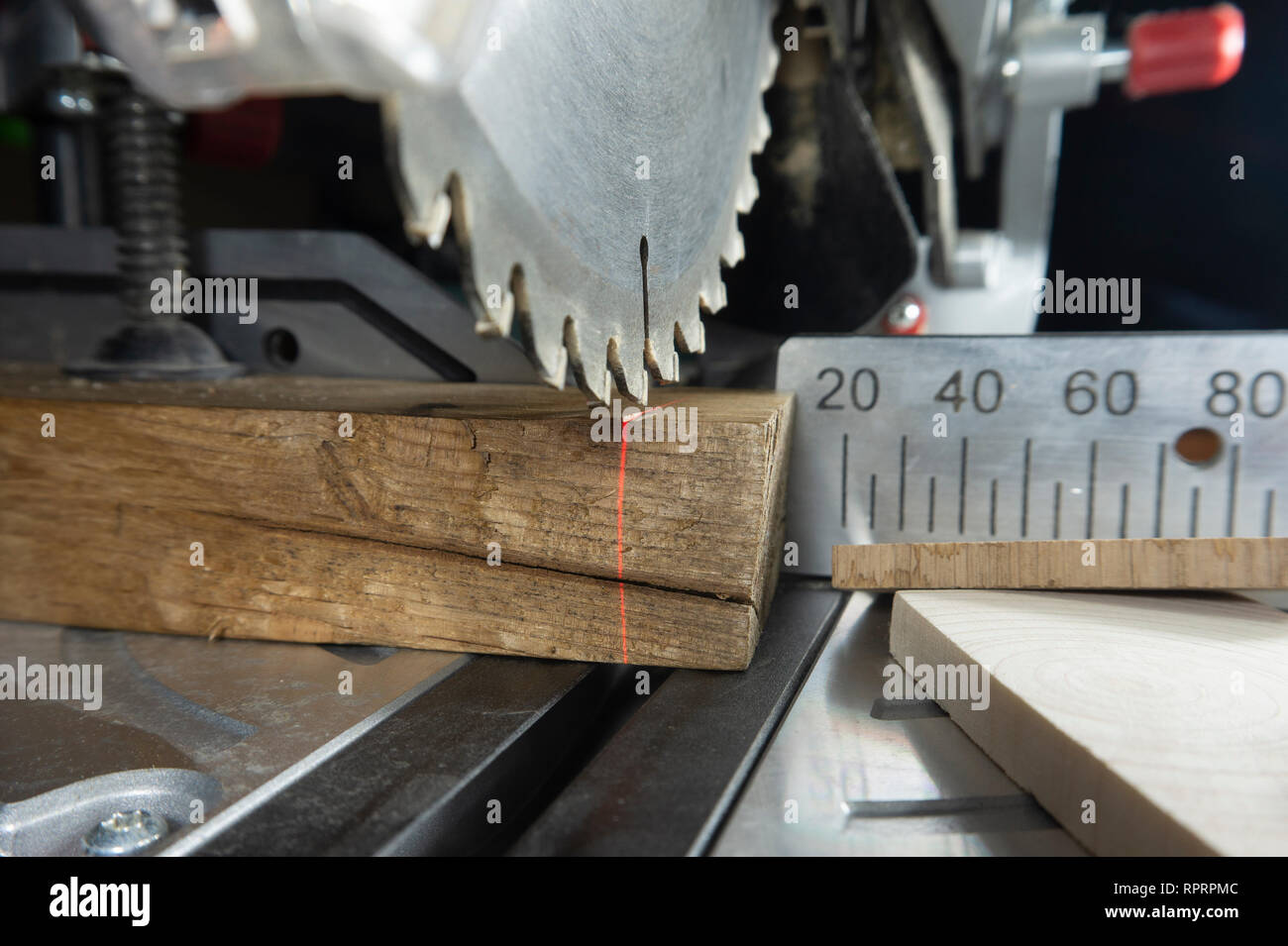 Teeth on a circular power saw in close up with assorted blocks of wood ...