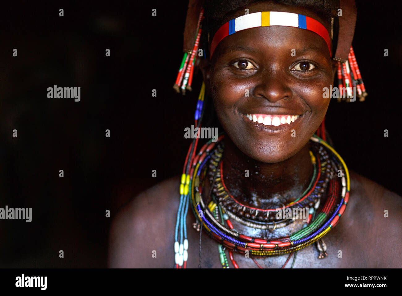 Portrait of a smiling Hakaona (Zemba) woman with traditional ornaments ...