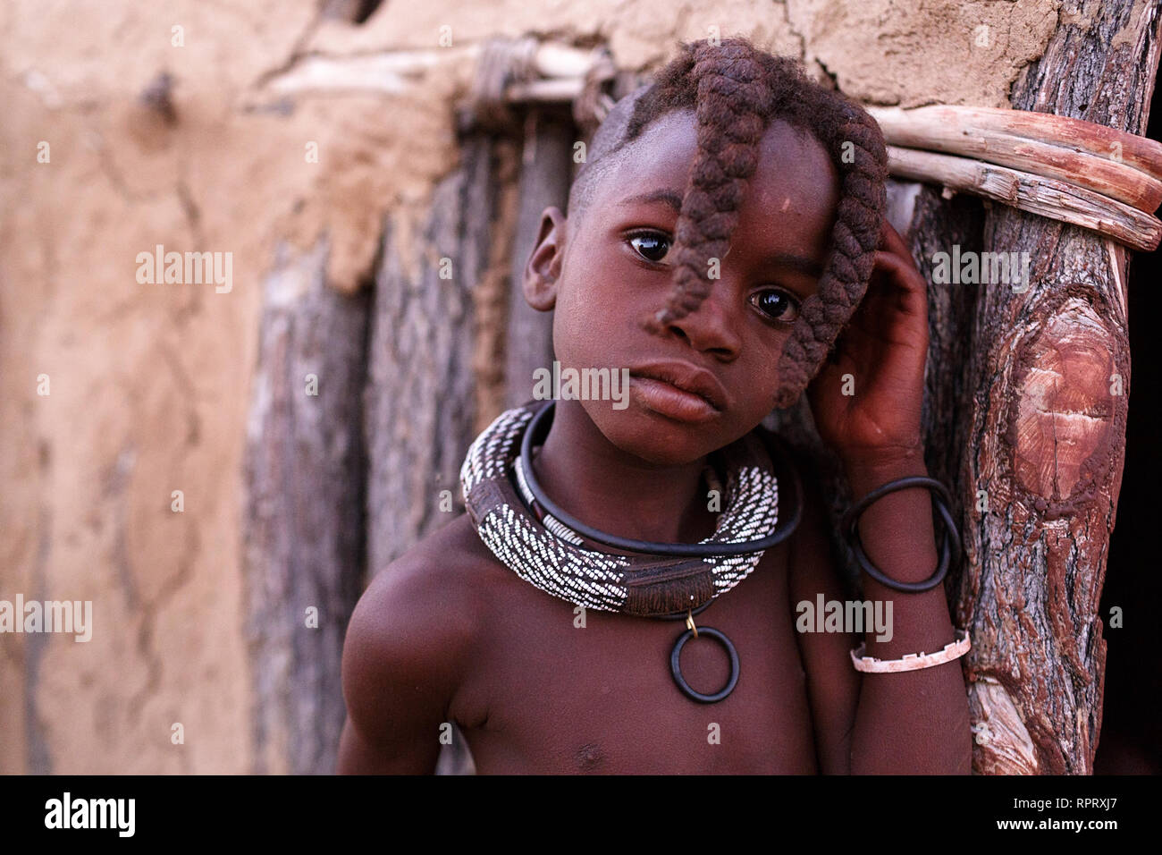 Himba girl with two braids and jewellery, portrait, Himba hut, Himba ...