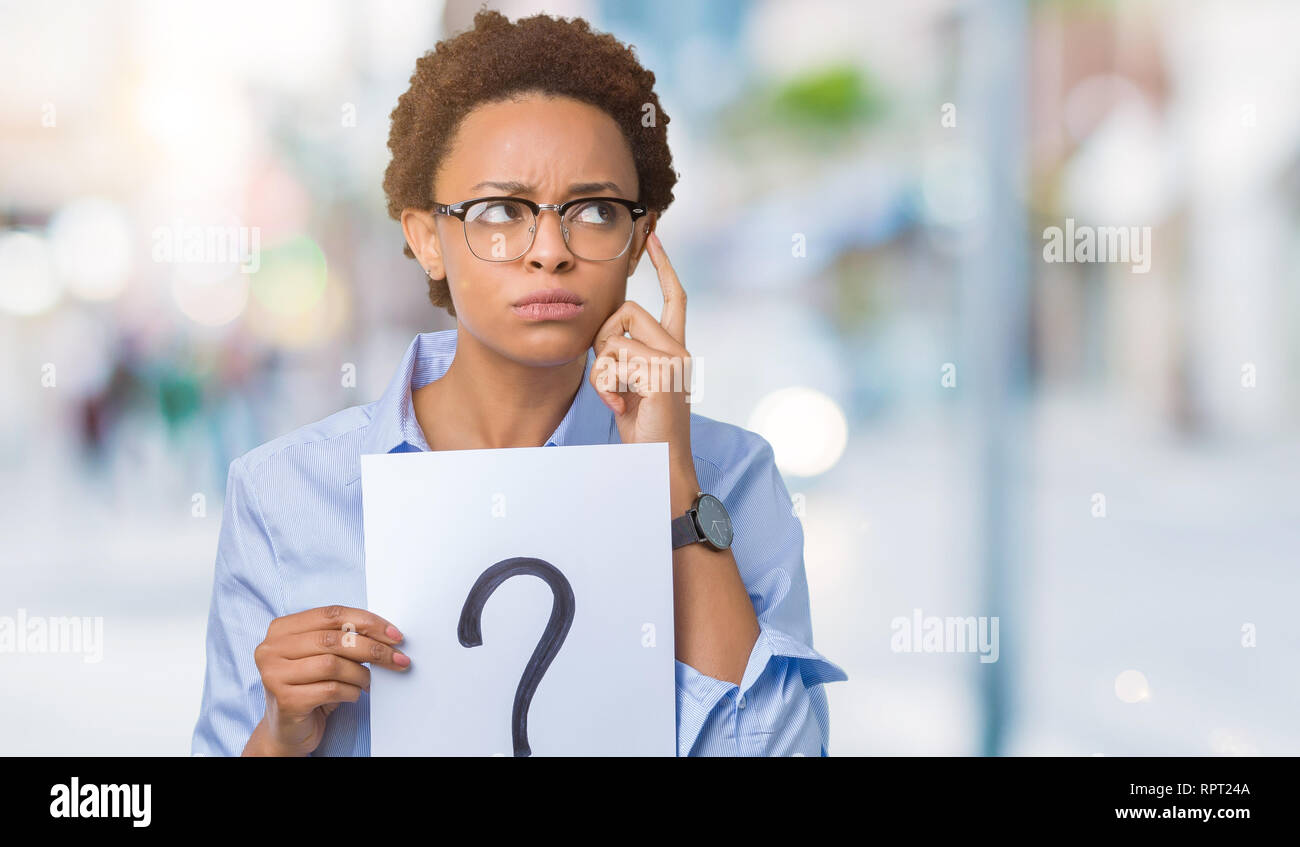 Young african american woman holding paper with question mark over ...