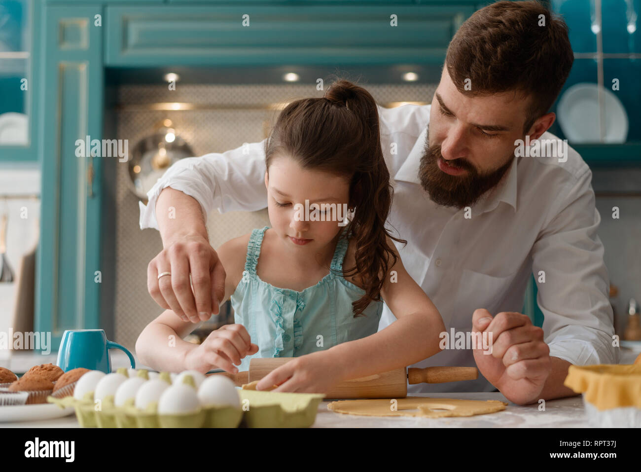 Dad helps daughter with cooking Stock Photo - Alamy