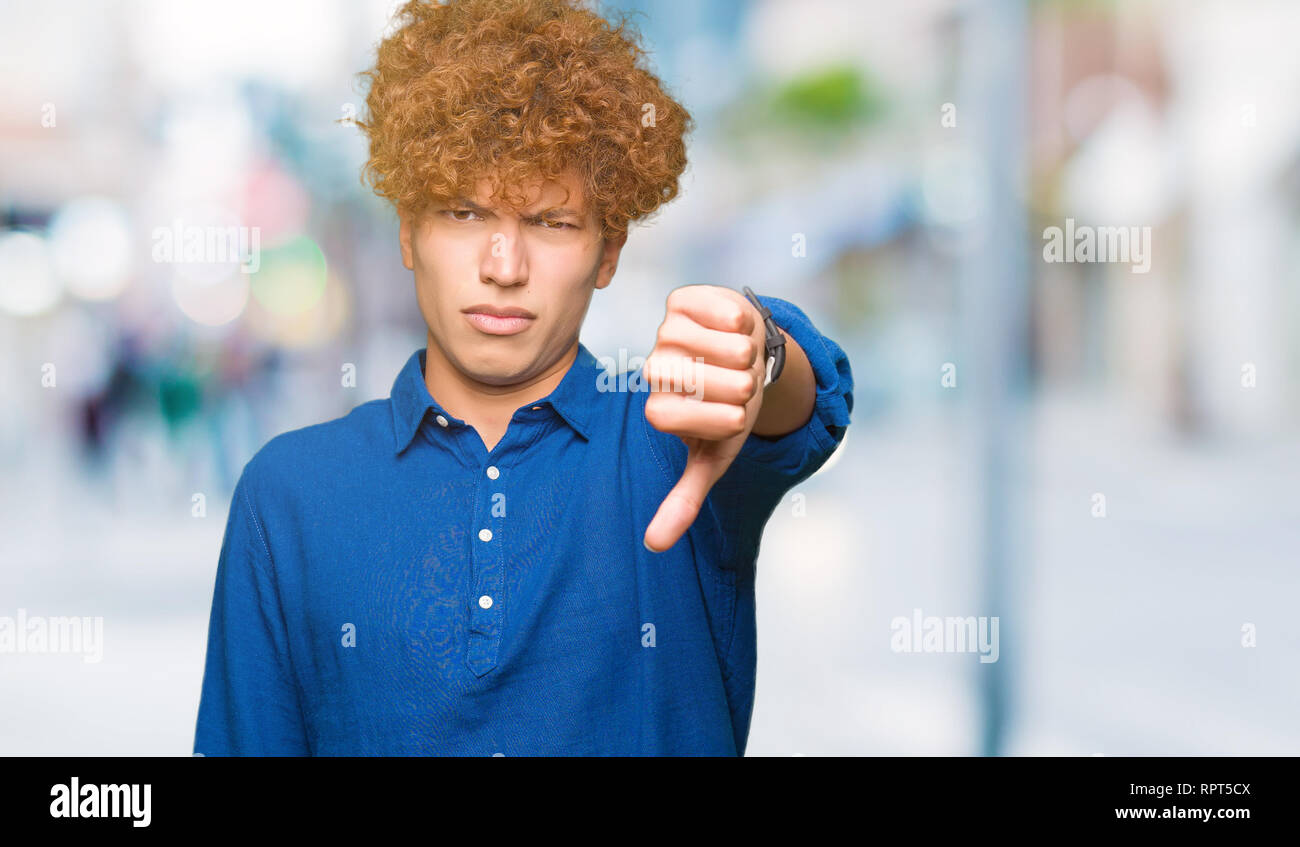 Young handsome elegant man with afro hair looking unhappy and angry ...
