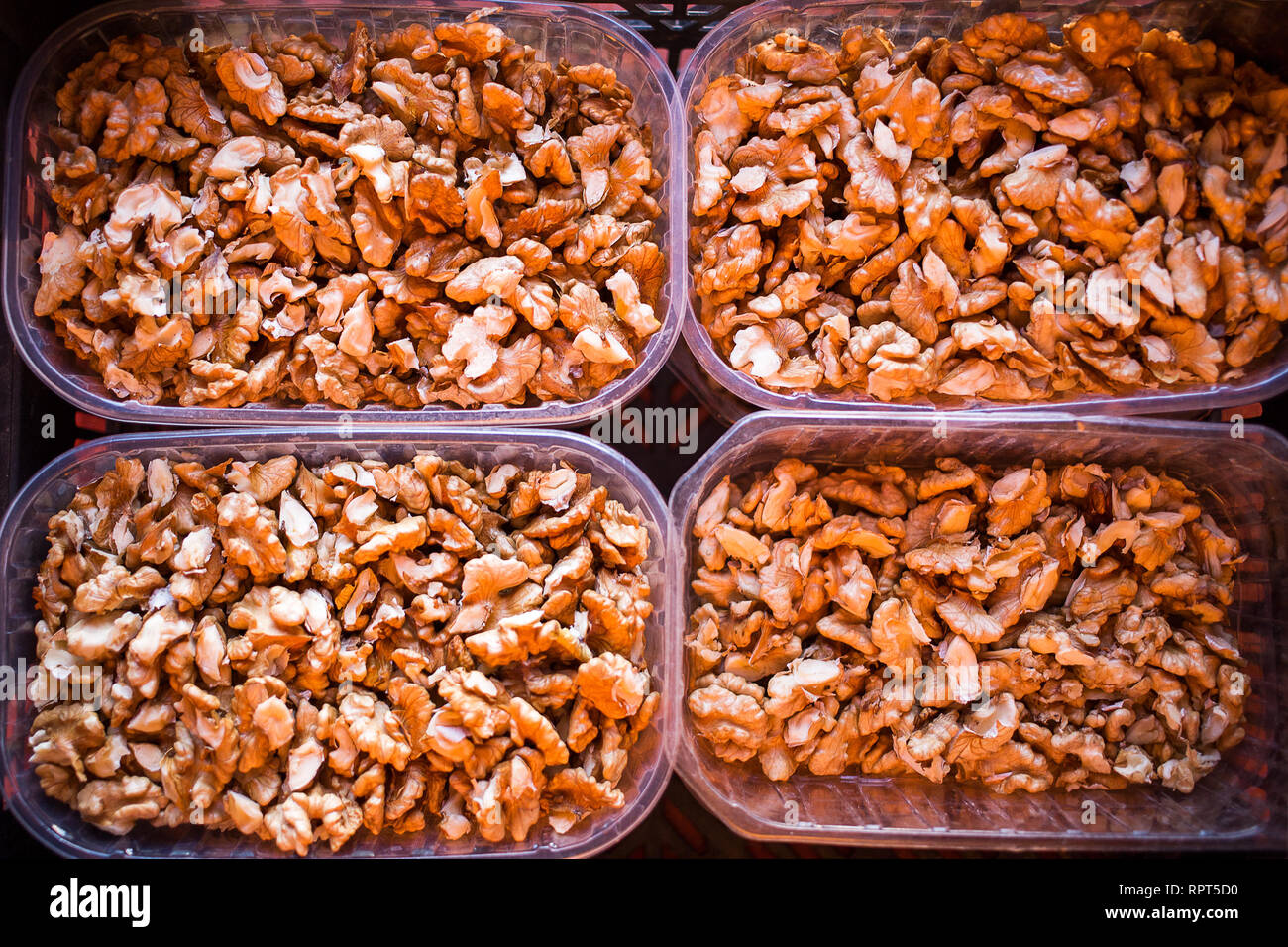 Four plastic recycled containers full of peeled delicious walnuts ready ...