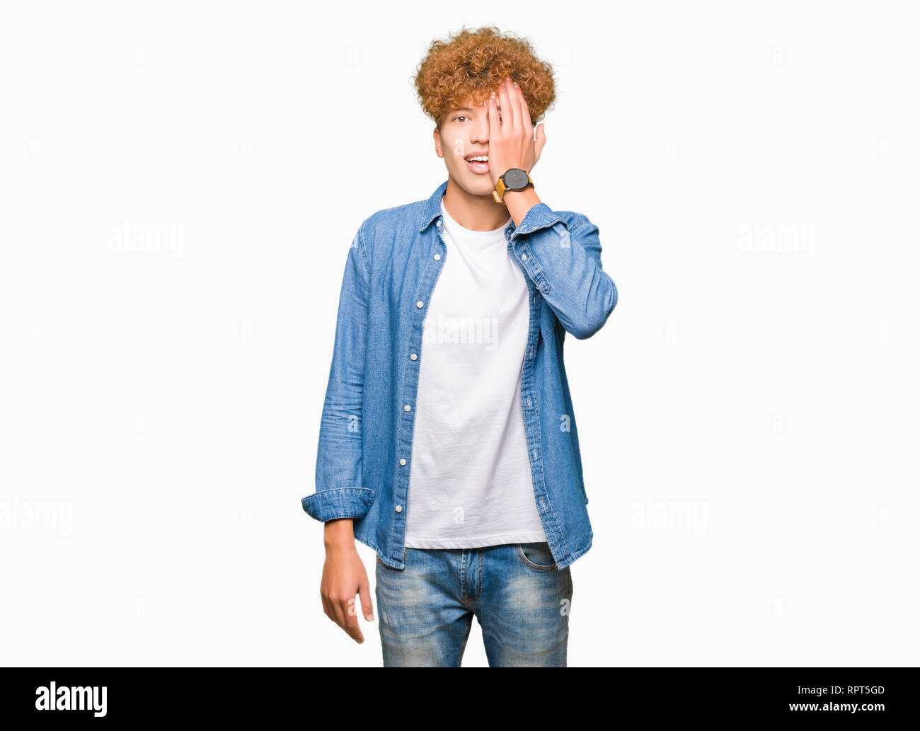 Young handsome man with afro hair wearing denim jacket covering one eye ...