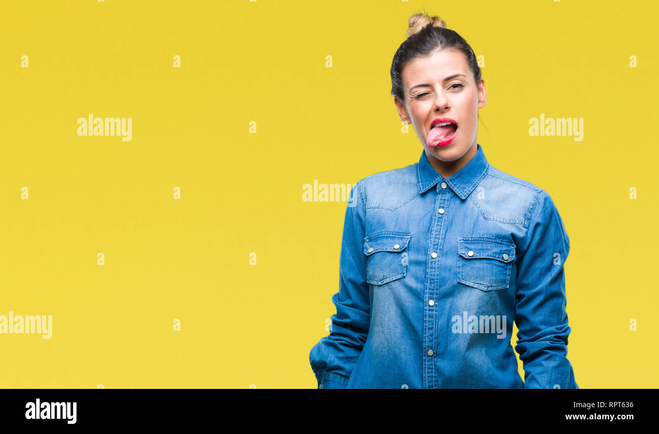 Young beautiful woman over isolated background sticking tongue out ...