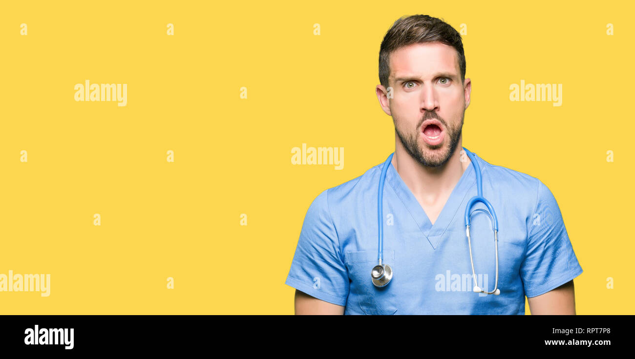 Handsome doctor man wearing medical uniform over isolated background In ...