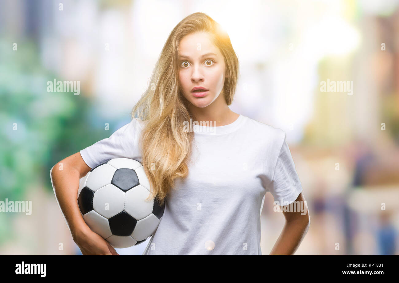 Young beautiful blonde woman holding soccer ball over isolated ...