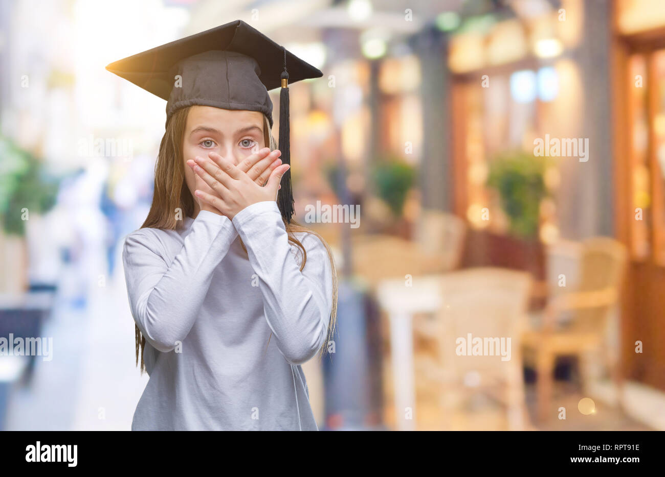 Young beautiful girl wearing graduate cap over isolated background ...