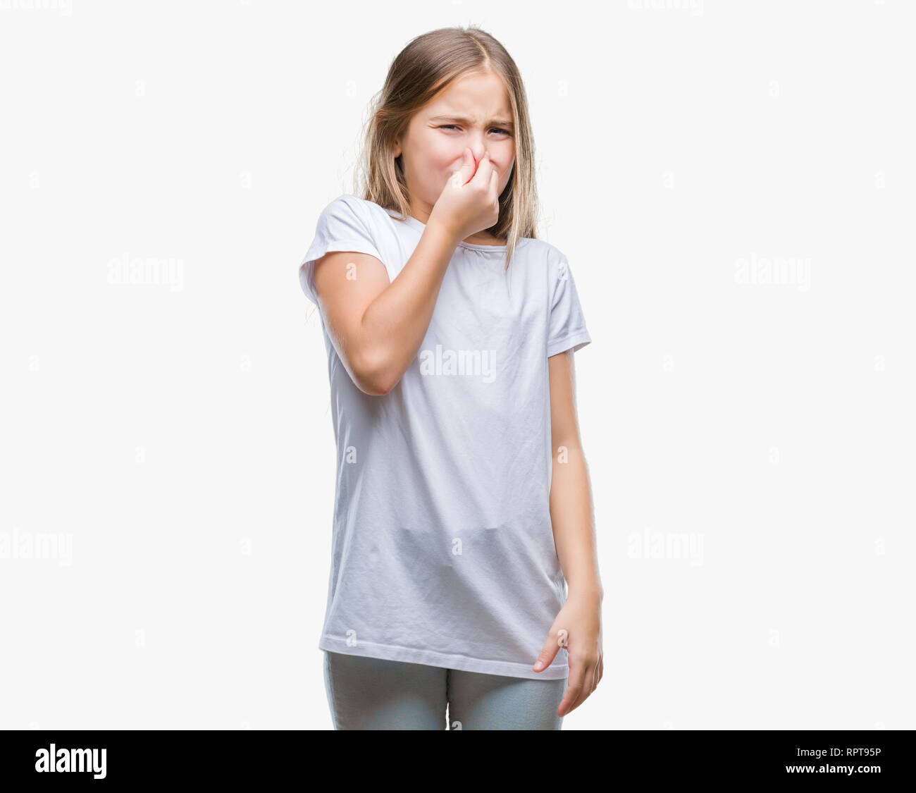 Young beautiful girl over isolated background smelling something stinky ...