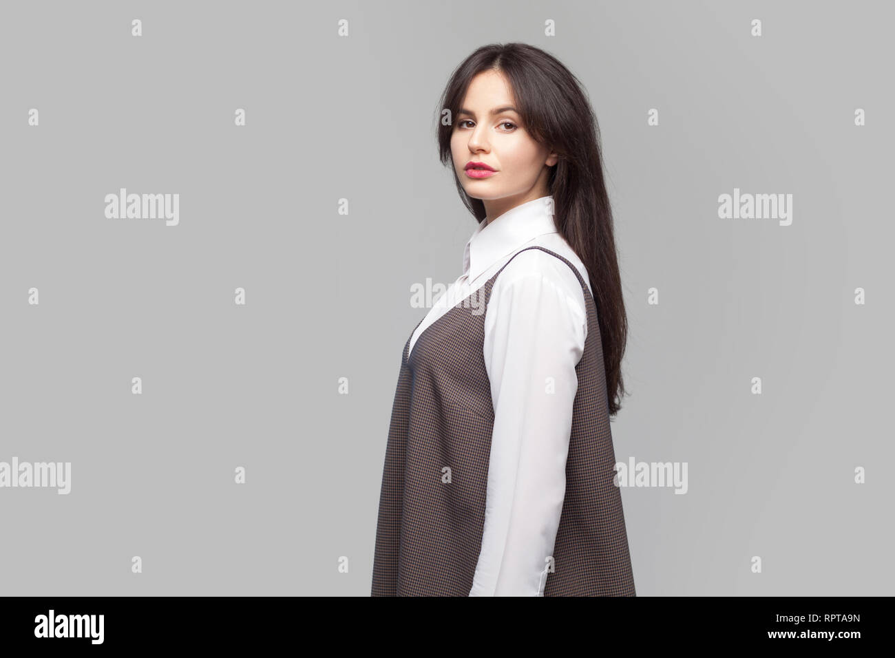 Side profile view portrait of serious beautiful young woman in white ...