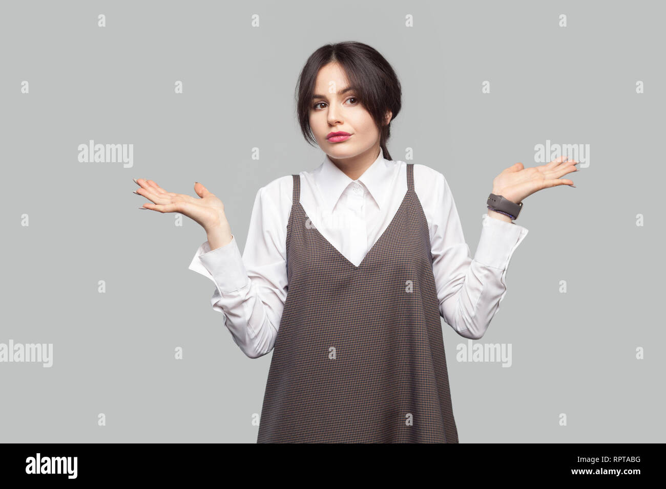 Portrait of confused thoughtful beautiful young woman in white shirt ...