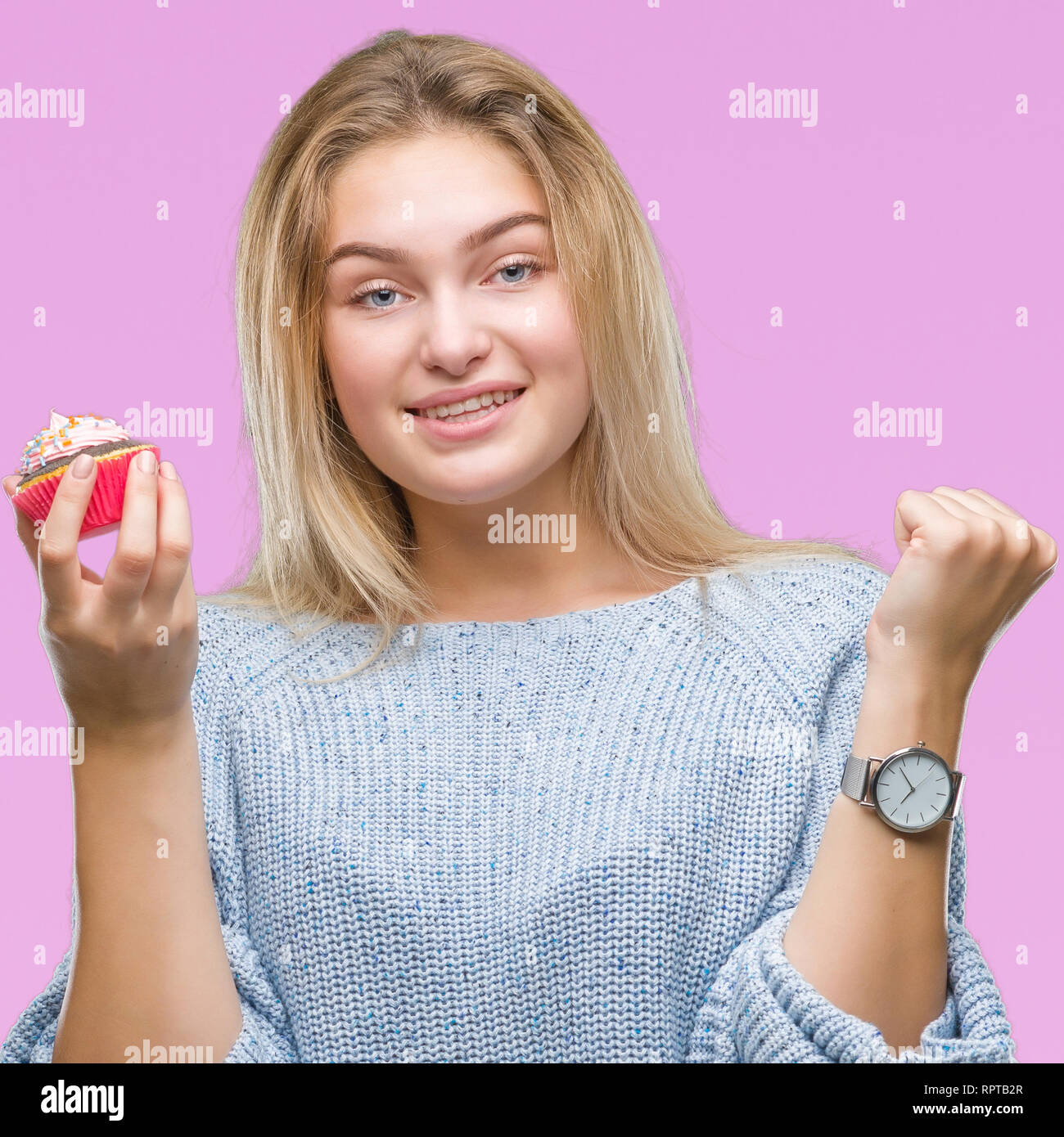 Young caucasian woman eating sweet cupcake over isolated background ...