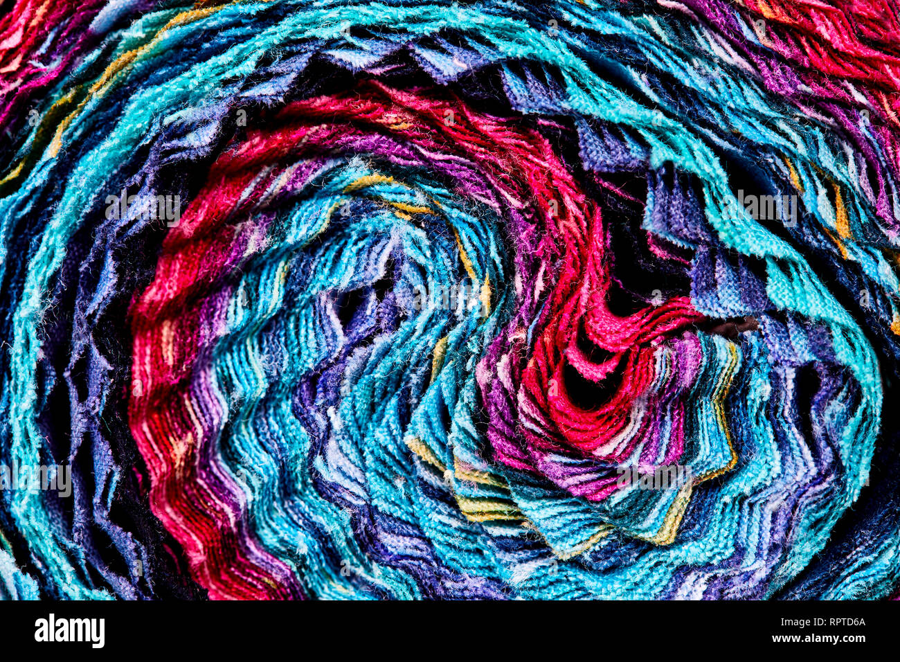 Multi-colored remnants of fabric rolled together to create a pattern ...