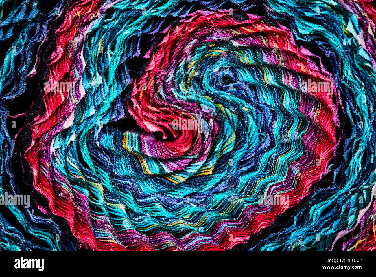 Multi-colored remnants of fabric rolled together to create a pattern ...