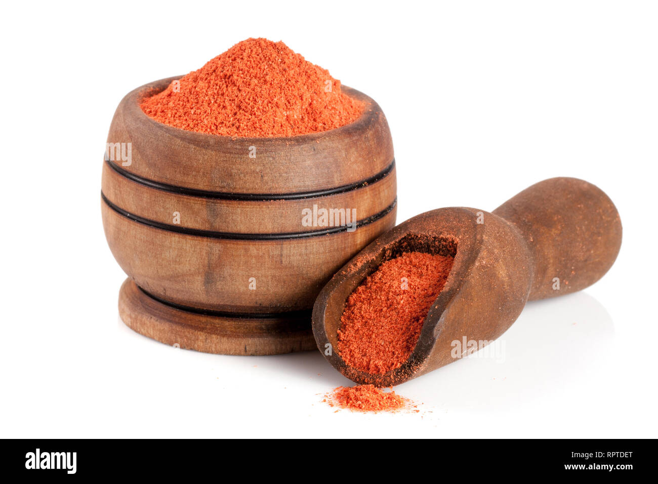 Ground paprika in a wooden bowl with a scoop isolated on a white ...
