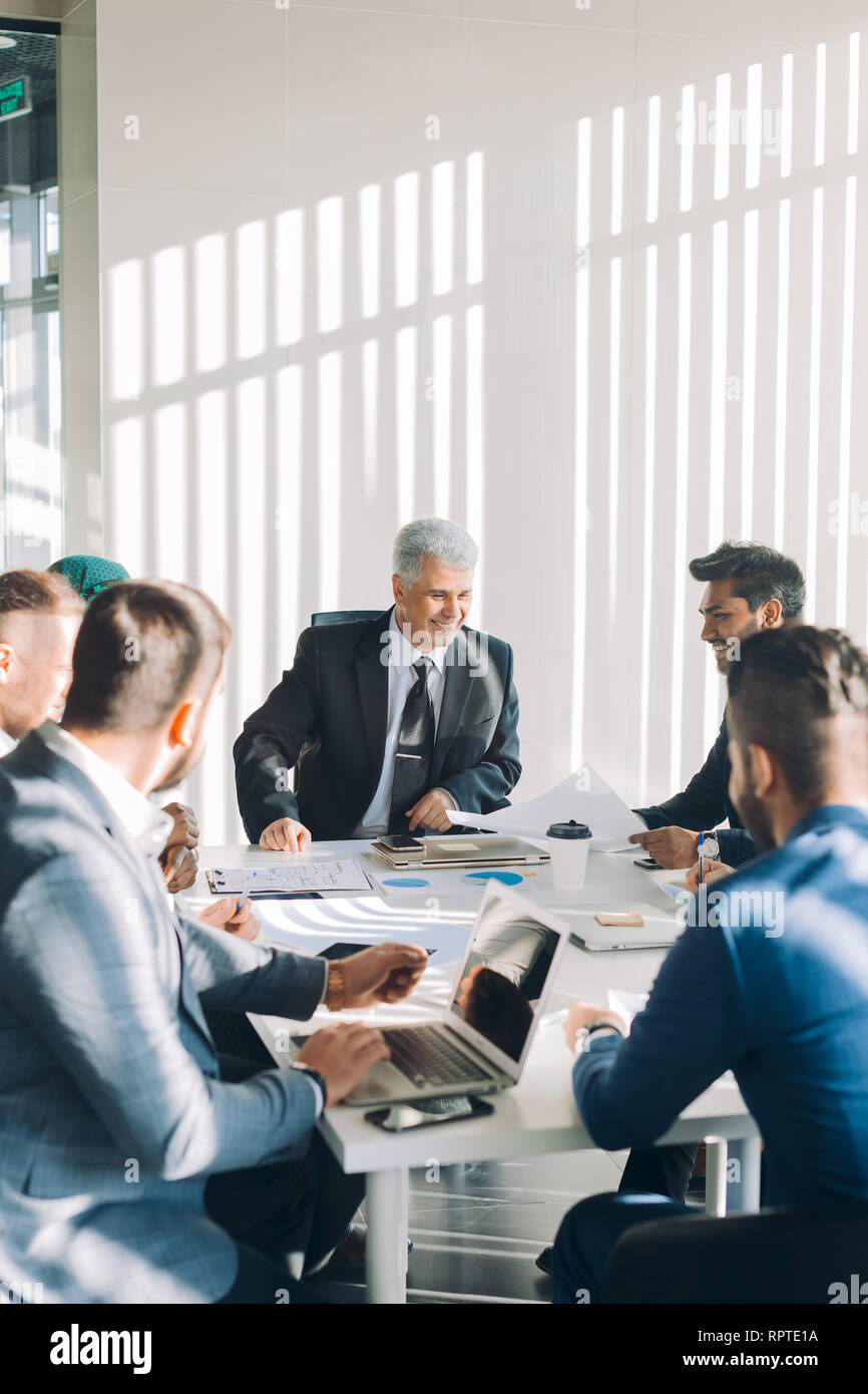Mature grey-haired financial director reporting to his multiracial top ...
