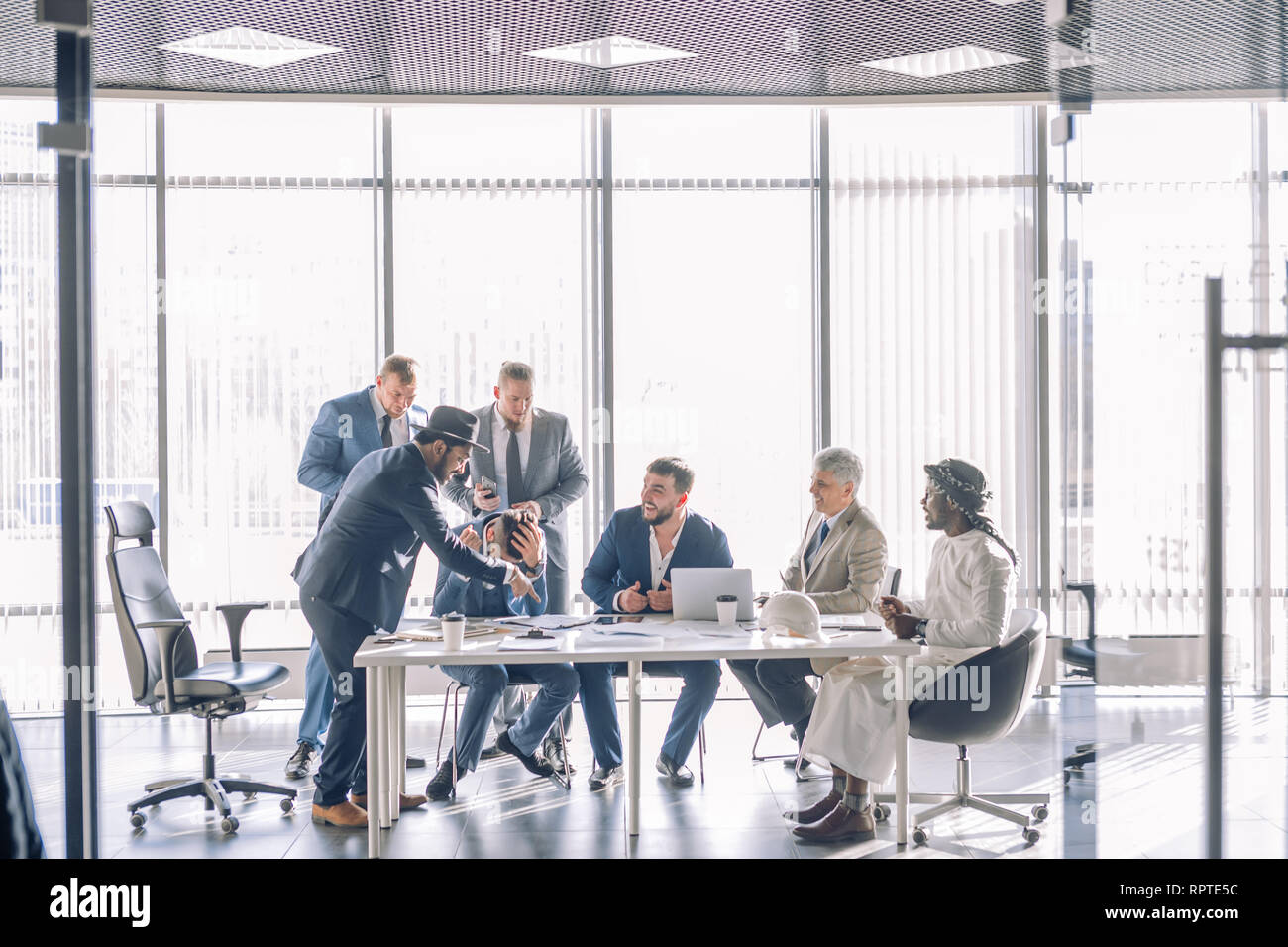 Cheeful multiracial group of businessmen having fun during meeting in ...
