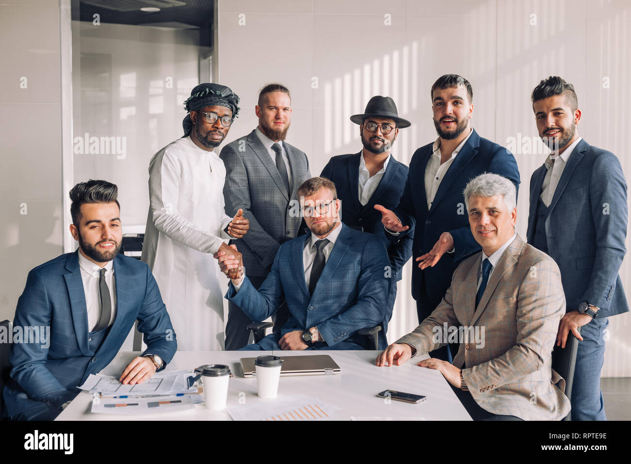 Confident multiethnic group of male business partners looking at camera ...