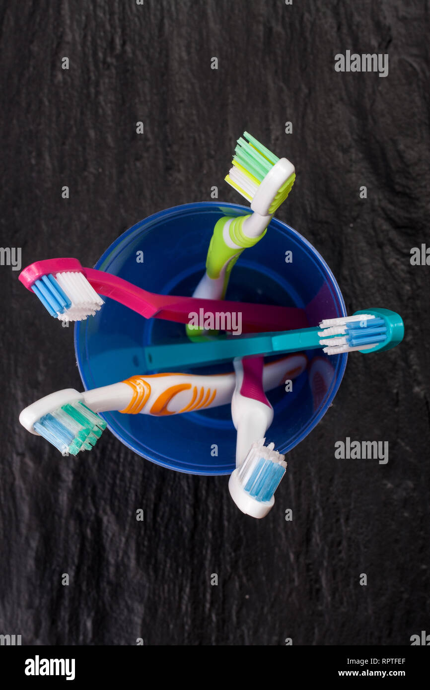 Toothbrushes in a blue plastic glass on black stone background Stock ...