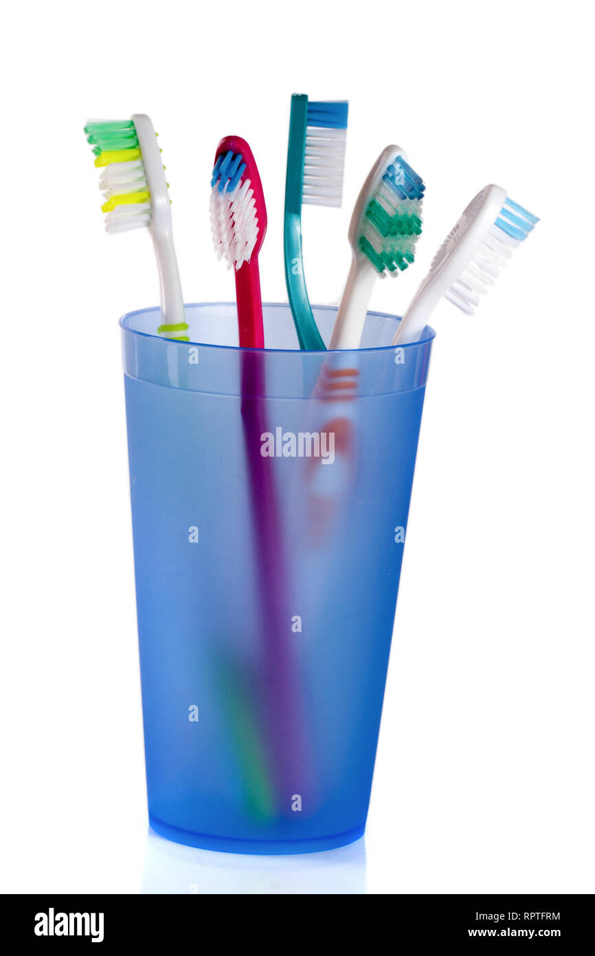 Toothbrushes in blue glass isolated on white background Stock Photo - Alamy