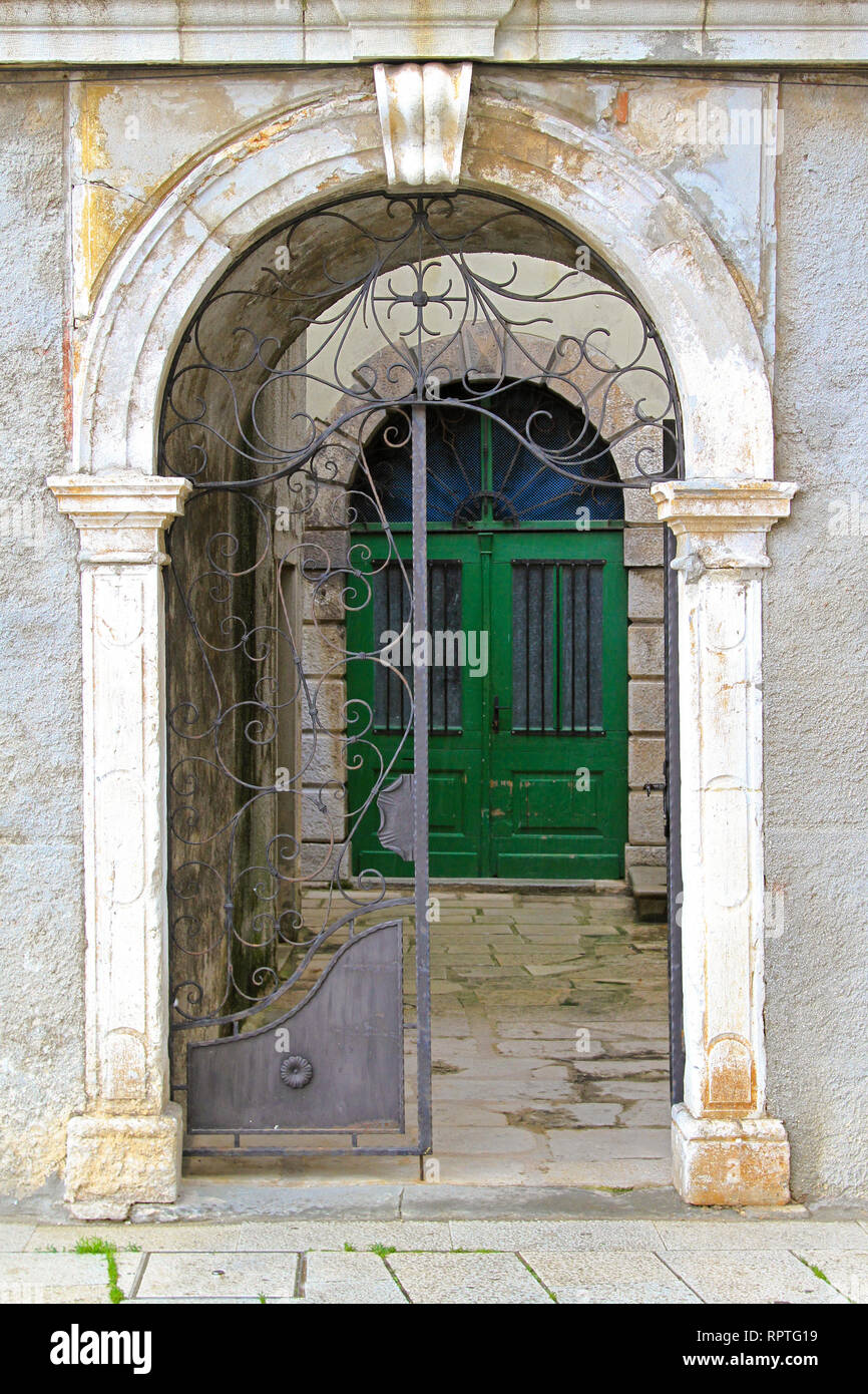 Iron work gate with stone arch hallway Stock Photo - Alamy